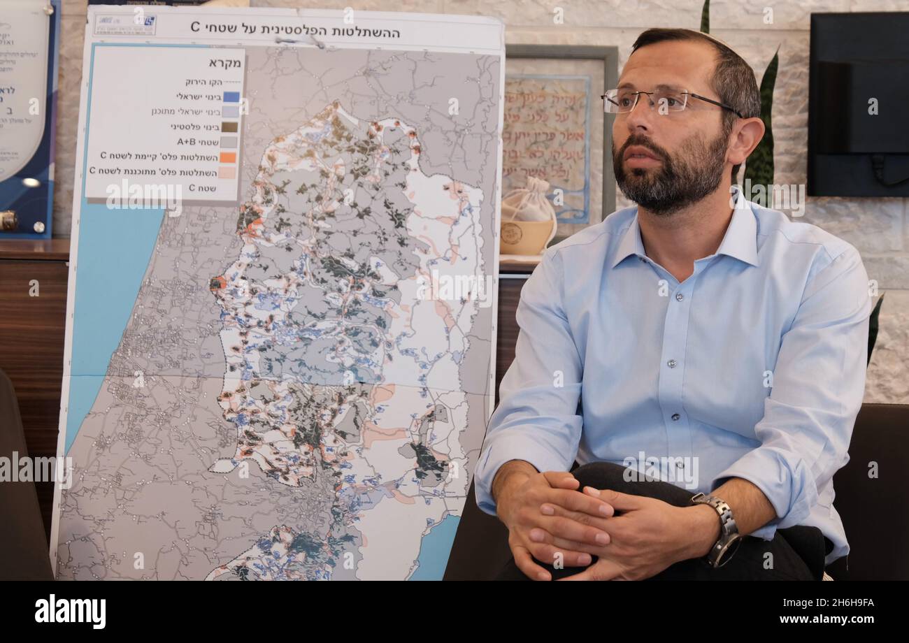 Mayor of the Binyamin Regional Council, Israel Ganz sits next to a map ...