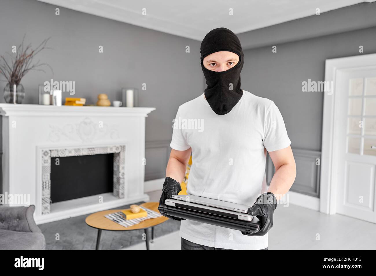 Thief with black balaclava stealing modern expensive television. Masked ...
