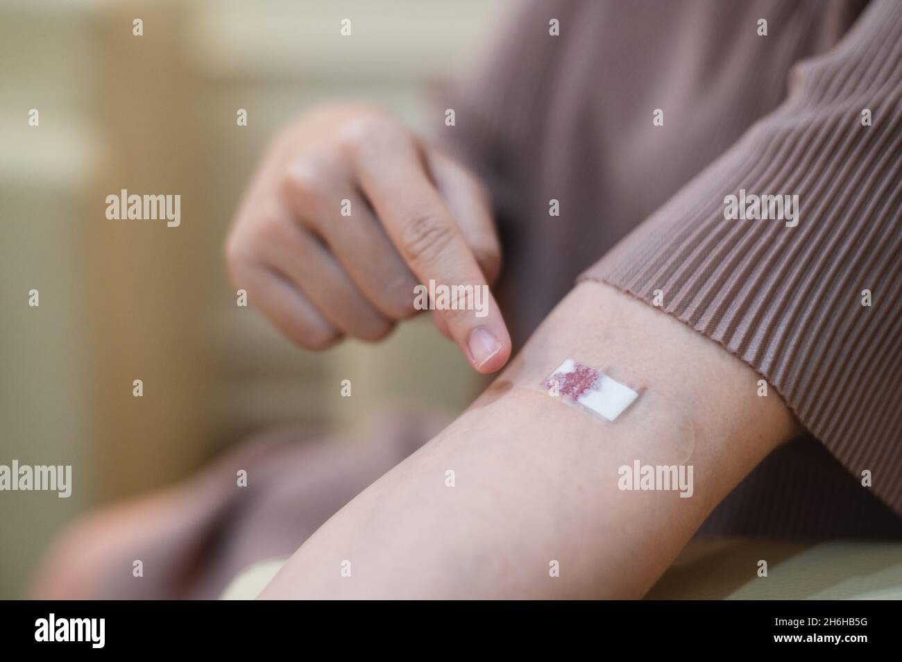 pregnant woman draws blood from an injection wound on a patient's arm ...