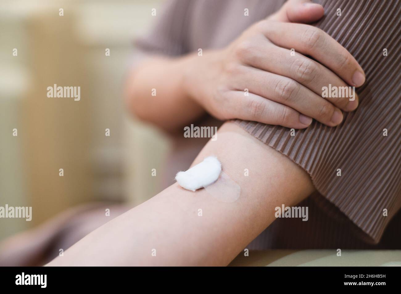pregnant woman draws blood from an injection wound on a patient's arm ...