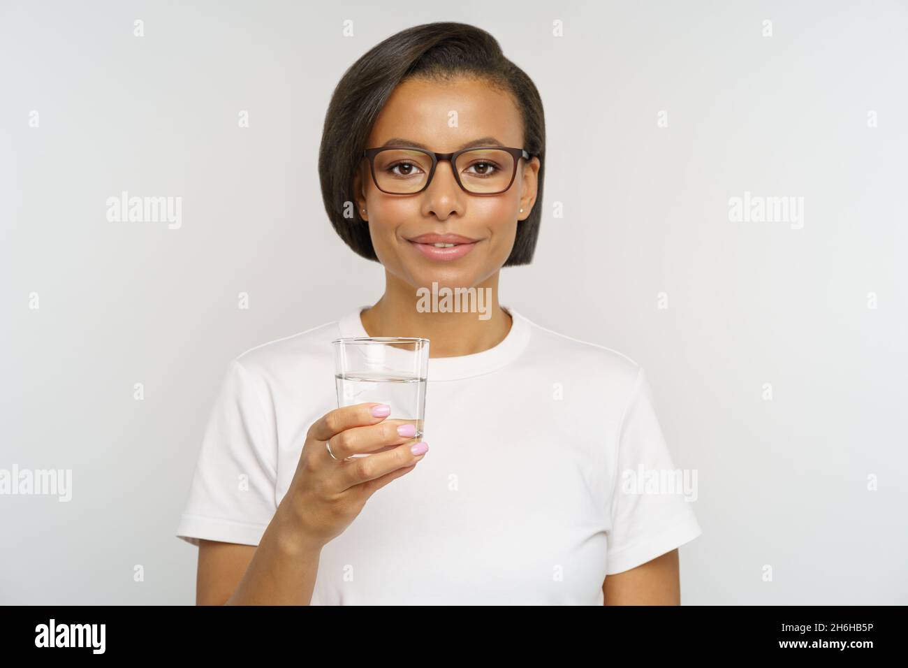 Young woman demonstrate glass of pure water for keeping hydration ...