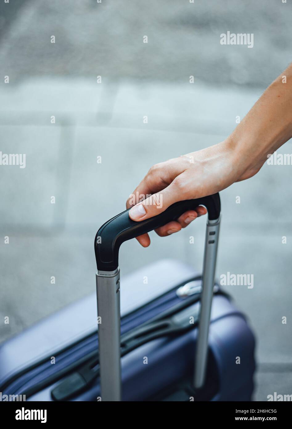 Close-up photo of a female hand holding suitcase. Young traveling woman ...