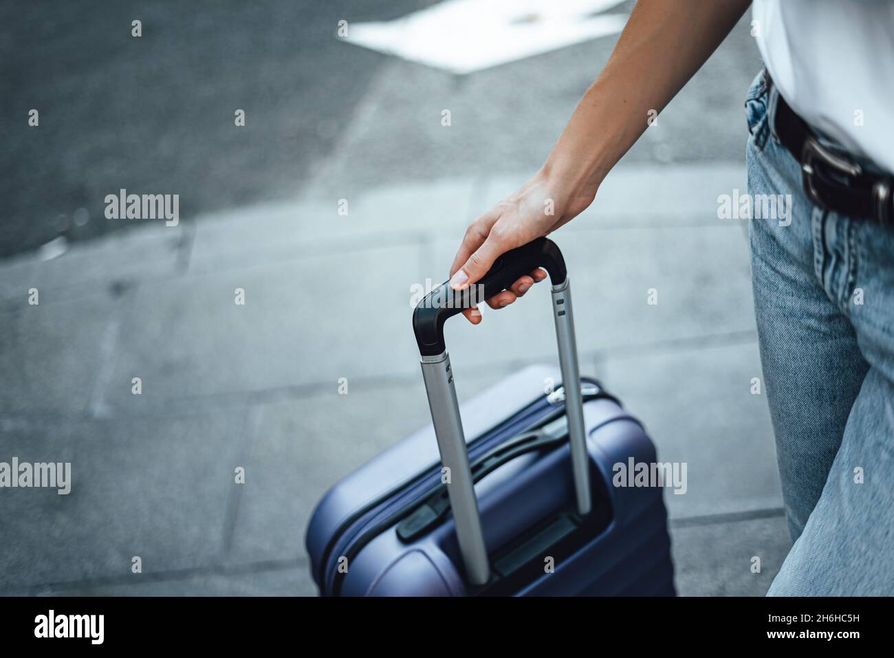 Close-up photo of a female hand holding suitcase. Young traveling woman ...