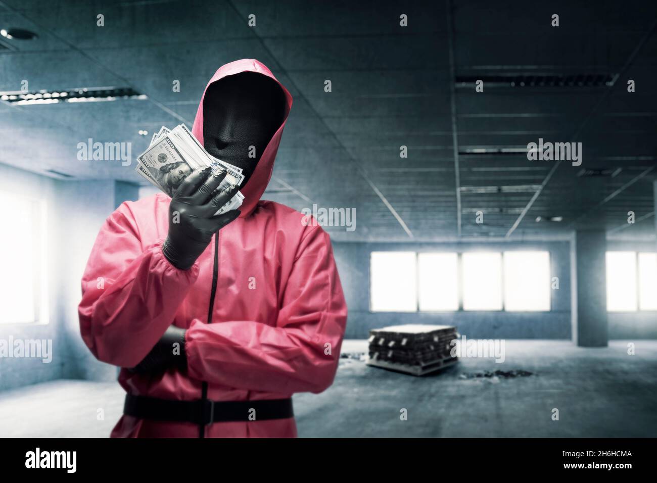 Criminal man in pink uniform and a hidden mask holding the money after ...