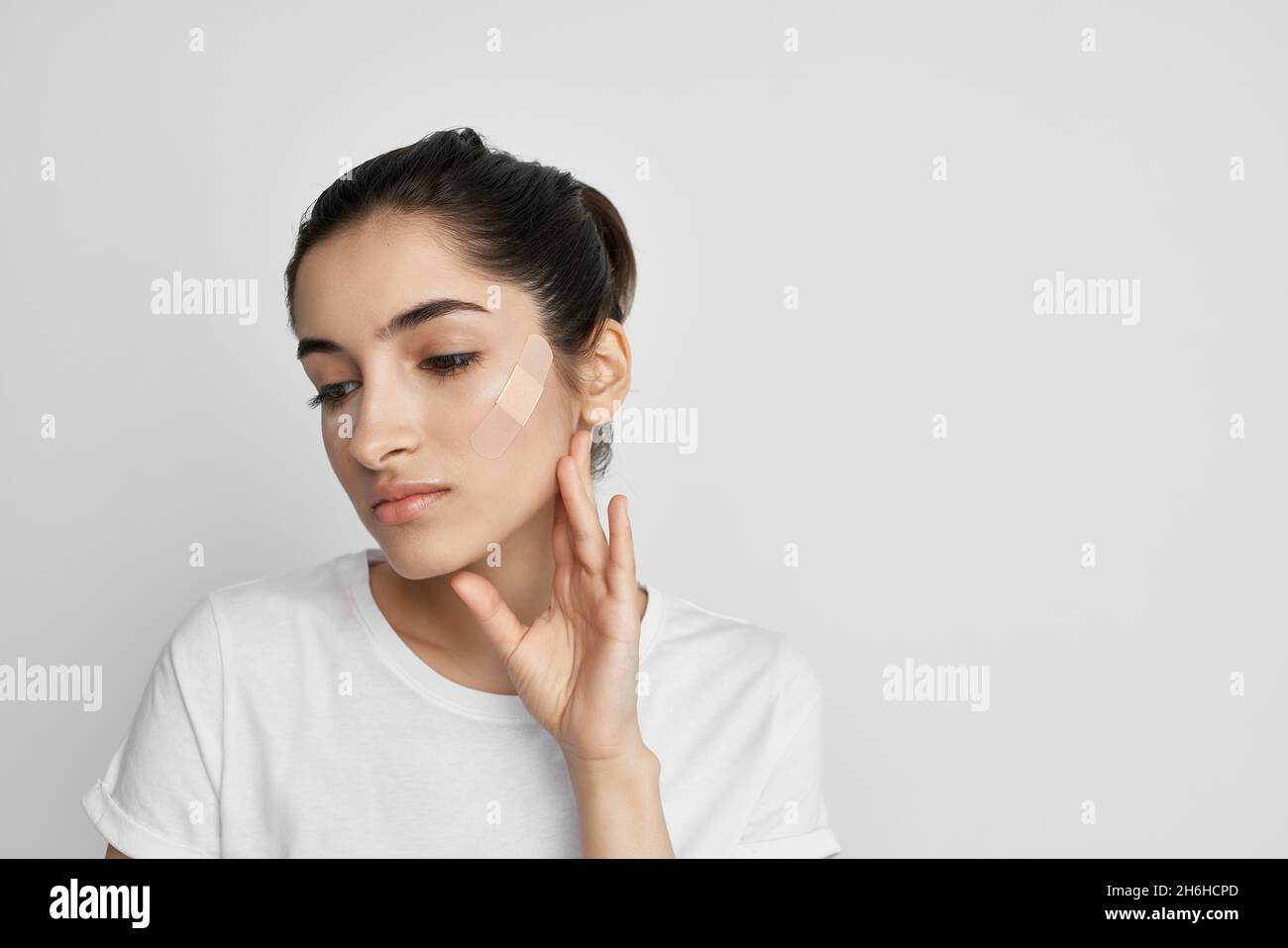 brunette patch on the face pain depression light background Stock Photo ...