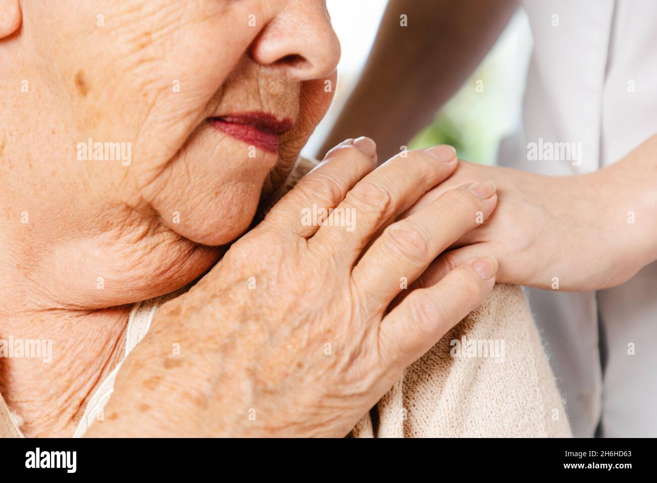International Day of Older Persons. Old woman clasped nurses hand ...