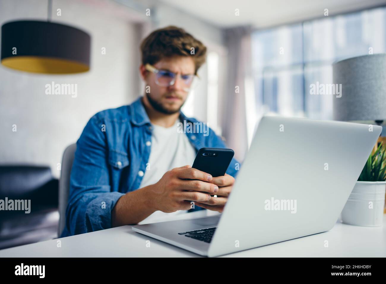 Young man with smartphone in his hands typing. Modern businessman at ...