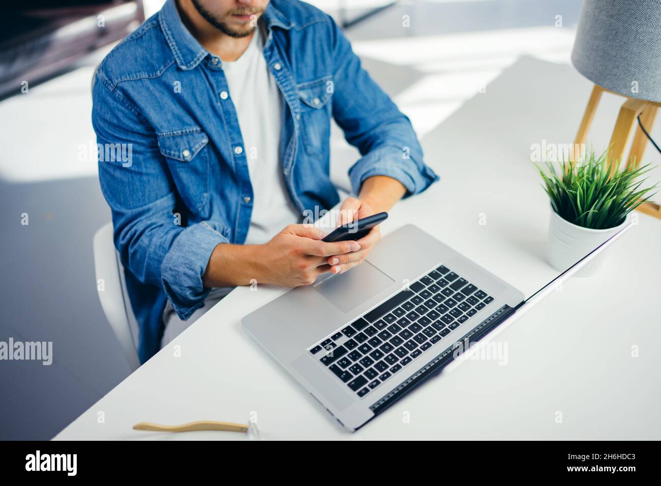 Young man with smartphone in his hands typing. Modern businessman at ...