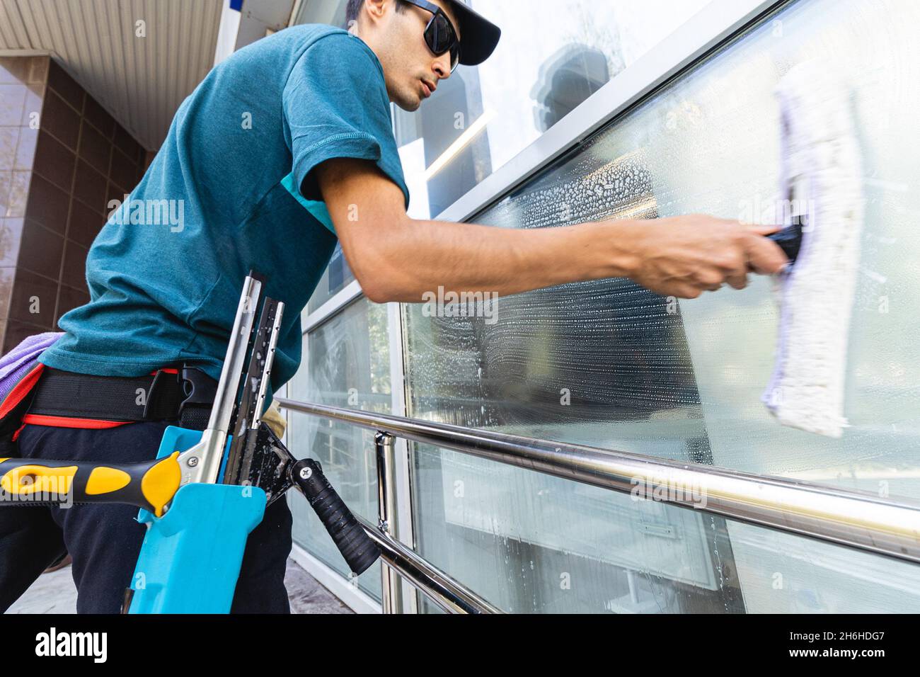 Male professional cleaning service worker in overalls cleans the ...