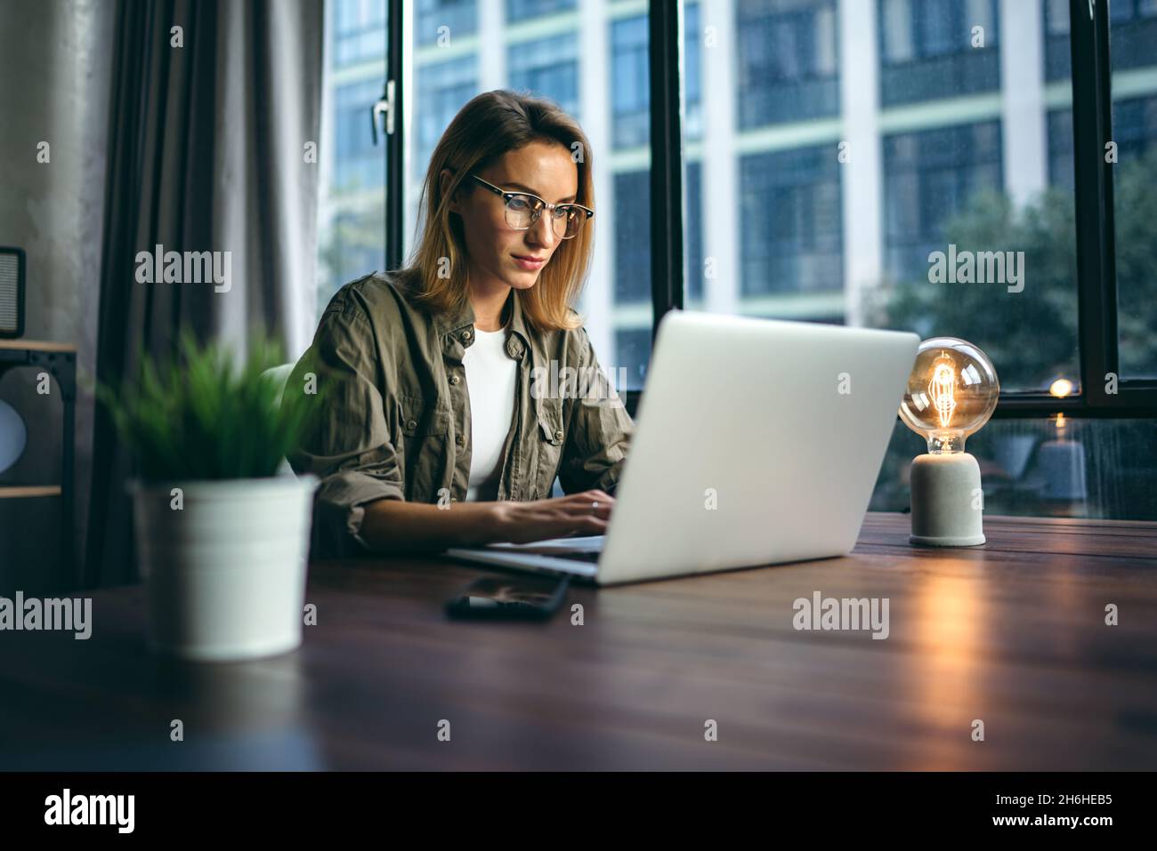 Young woman working with a laptop. Female freelancer connecting to internet via computer ...