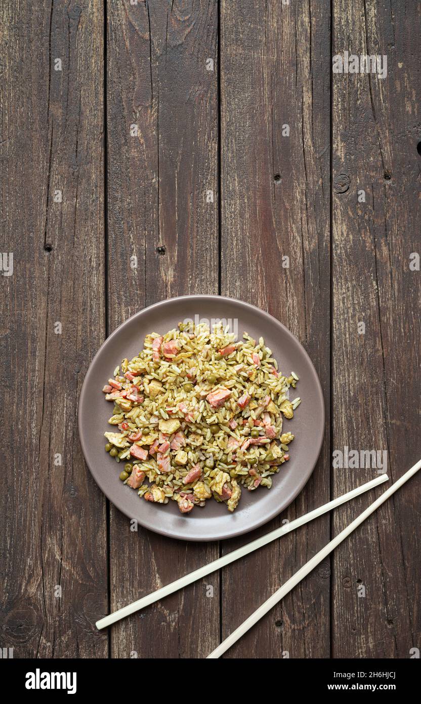 Cantonese rice or Chinese fried rice in a plate and wooden chopsticks ...