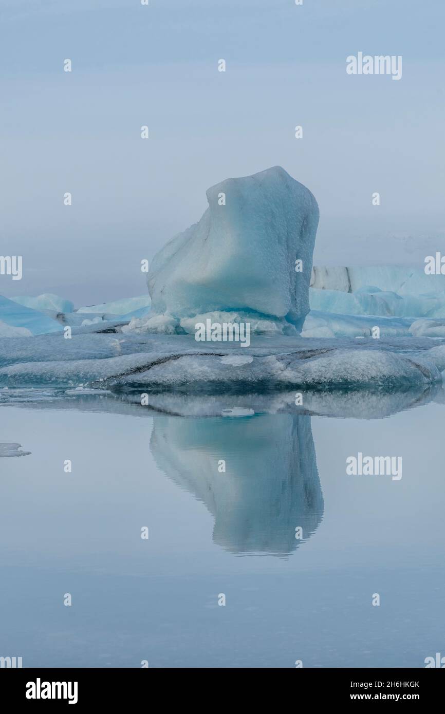 Iceberg in the ice field with reflection on a lagoon, arctic landscape ...
