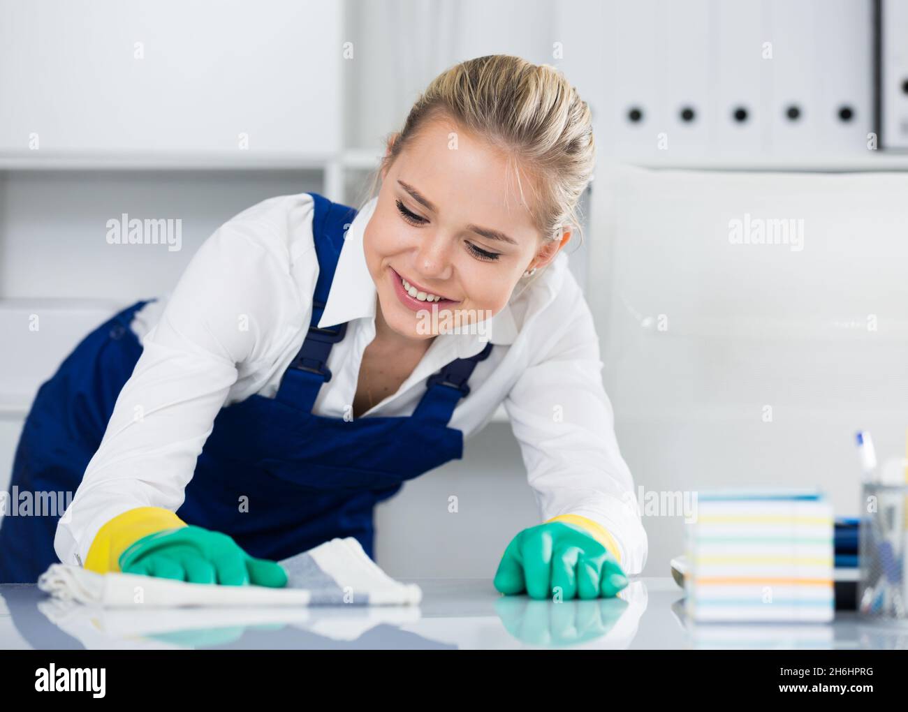 Woman cleaner wiping desk in office Stock Photo - Alamy