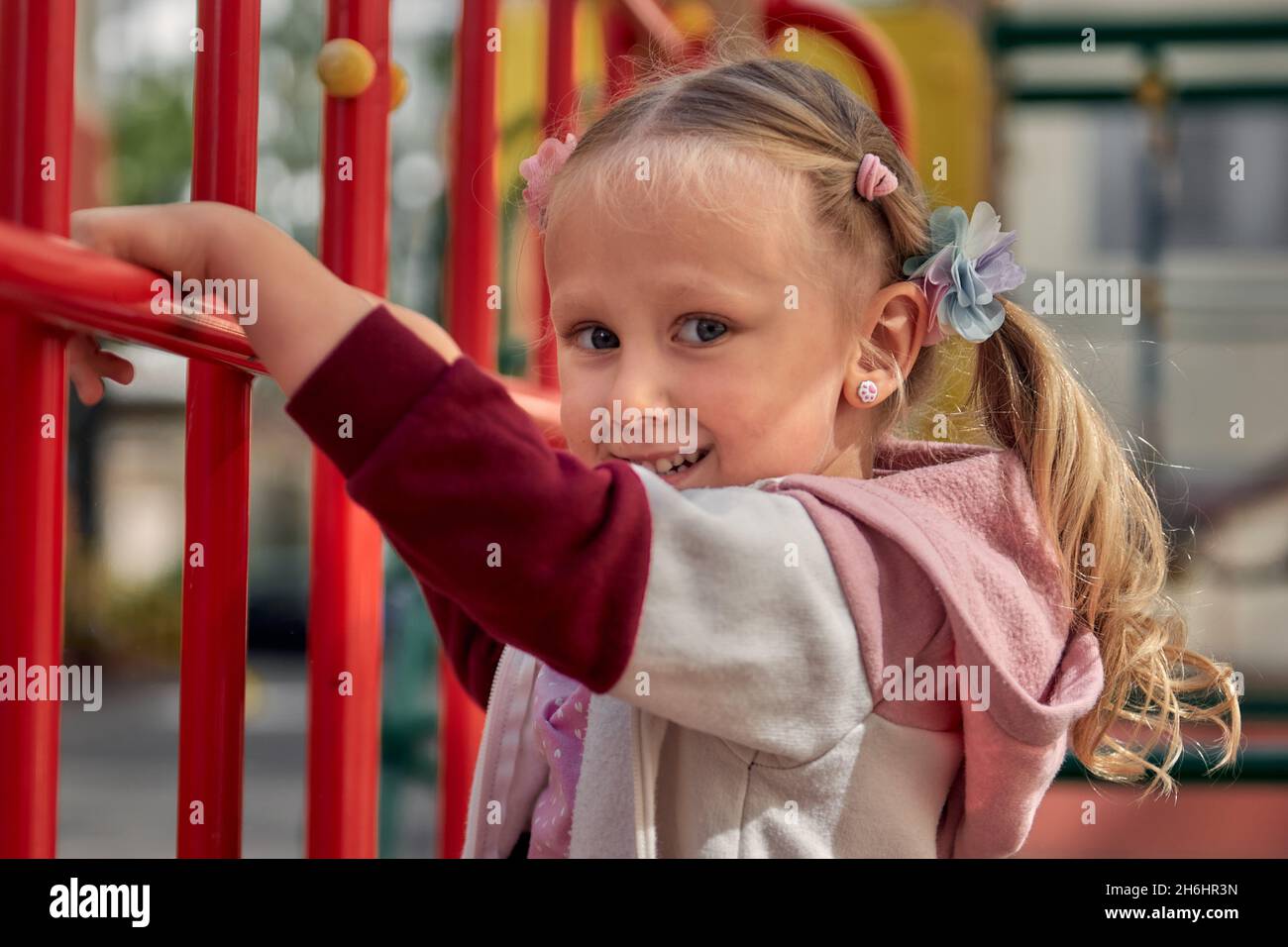 Kids play on the playground. Happy laughing girl have fun swinging and ...