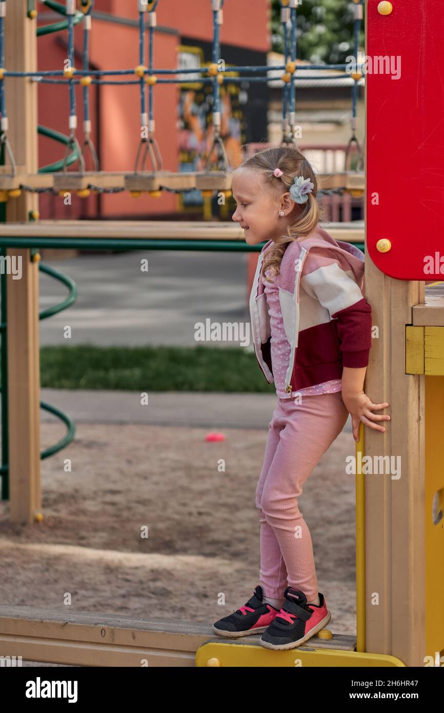 Kids play on the playground. Happy laughing girl have fun swinging and ...