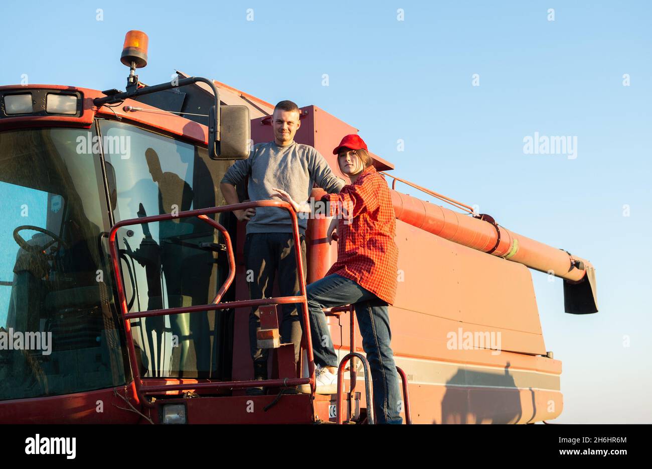 Two farmers man and woman on a combine harvester Stock Photo - Alamy