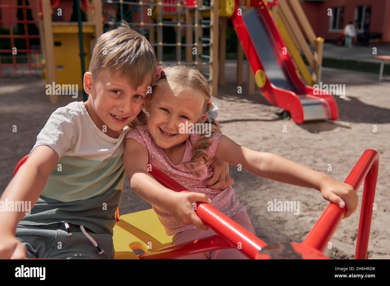 Kids play on the playground. Happy laughing boy and girl have fun ...
