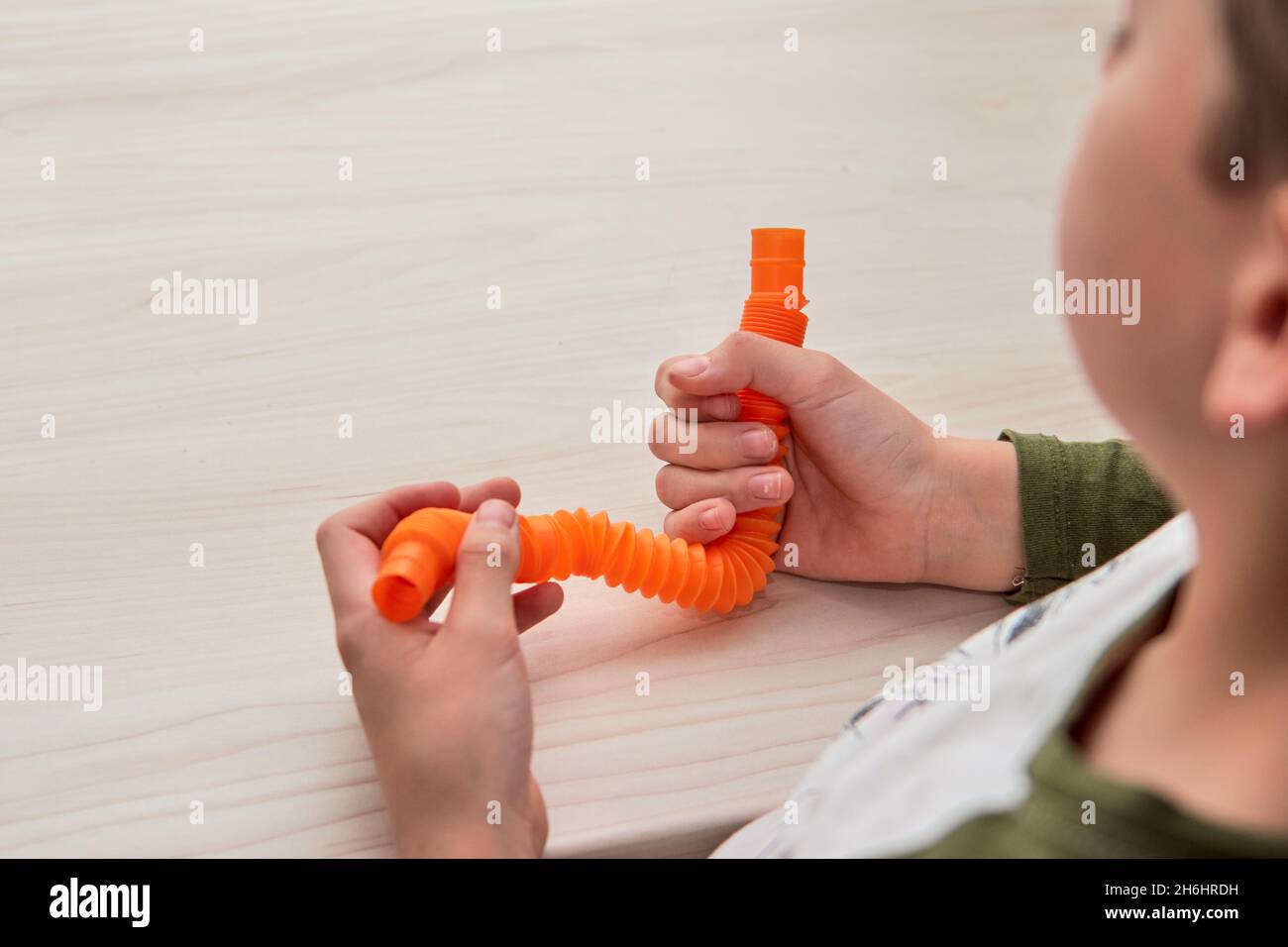 Kids hands push sensory pop tube. Colorfull antistress toys, pop it ...