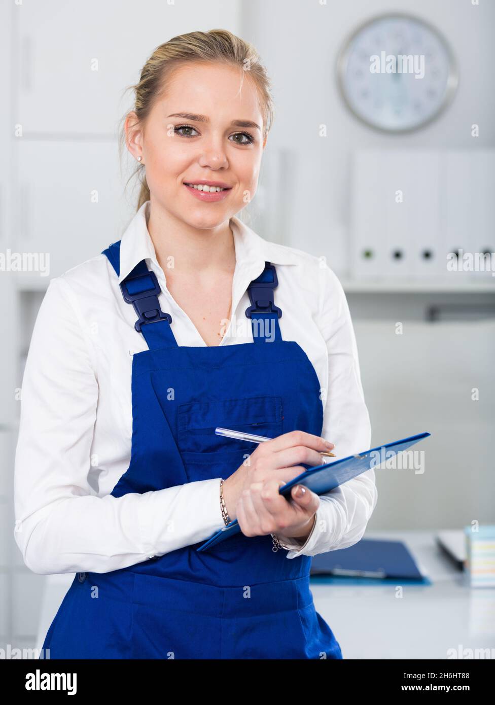 Girl in overall writing tasks Stock Photo - Alamy