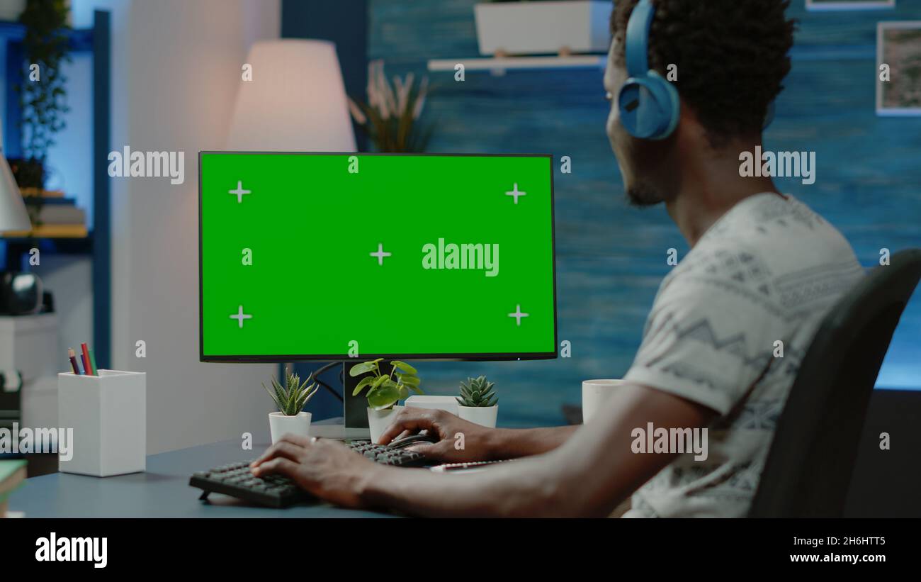 Adult looking at horizontal green screen on computer for work. Employee ...