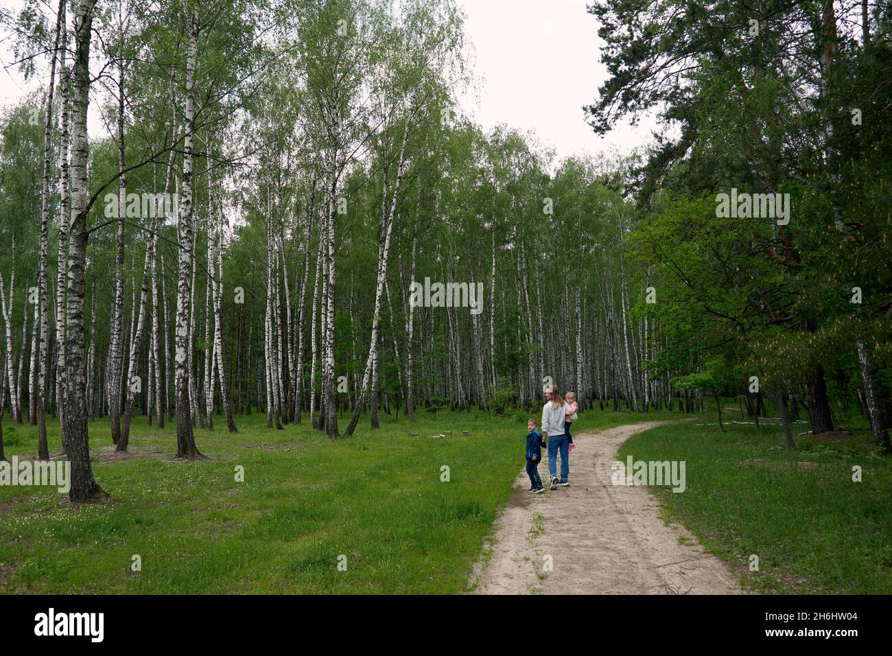 Happy loving mother and two children, son and daughter hiking in forest ...