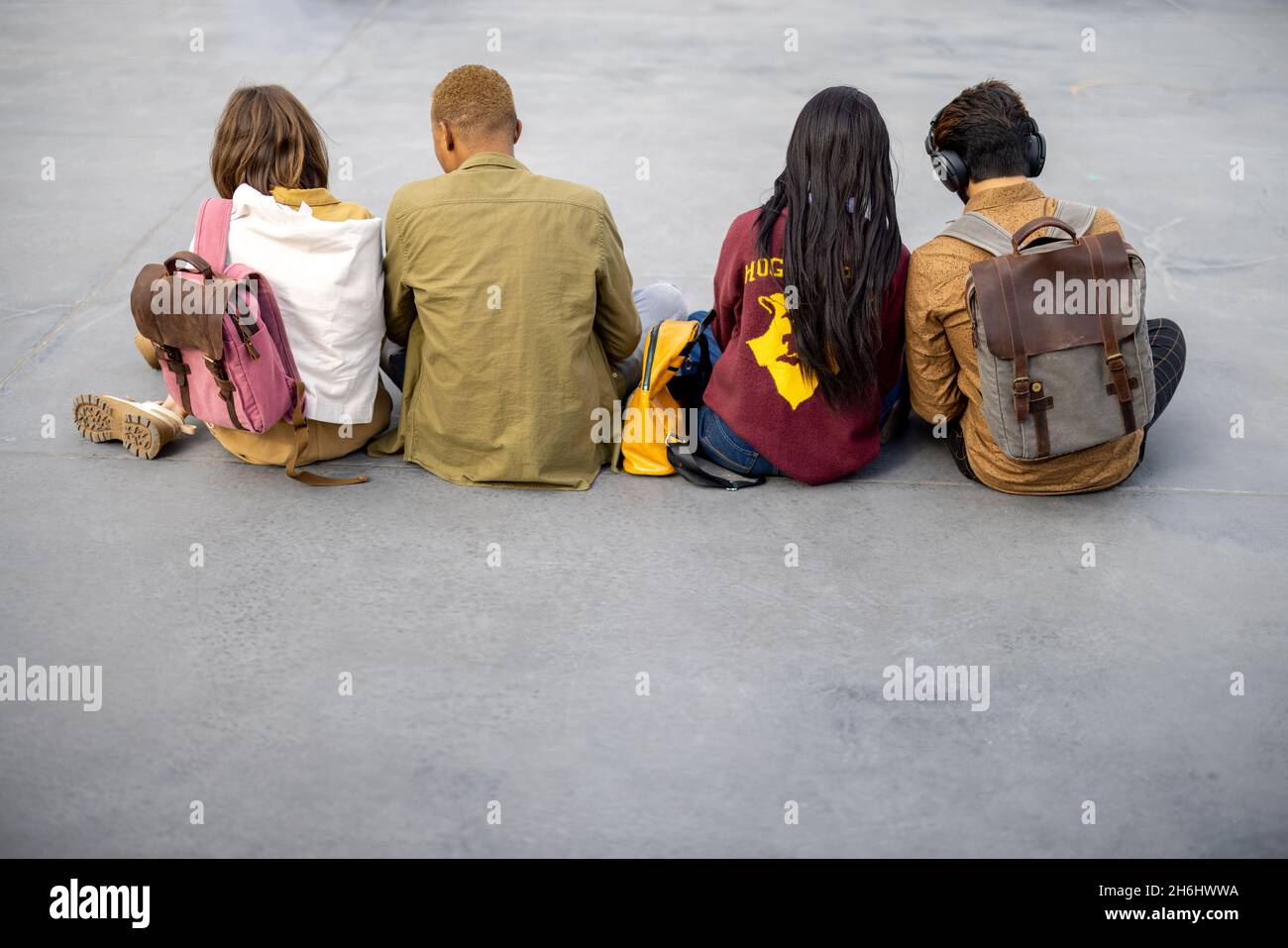 Back view of students sit and rest on asphalt Stock Photo - Alamy