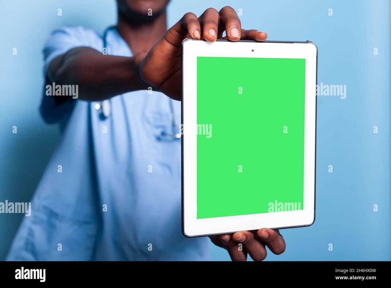 Medical assistant holding digital tablet with green screen. Man working ...