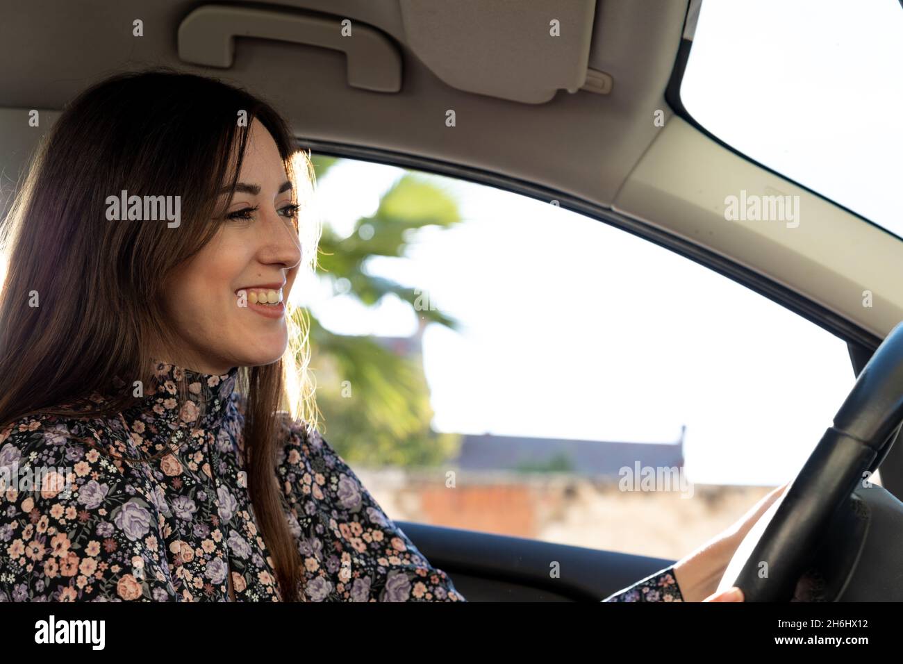 Confident and happy young brunette lady driving in a car Stock Photo ...