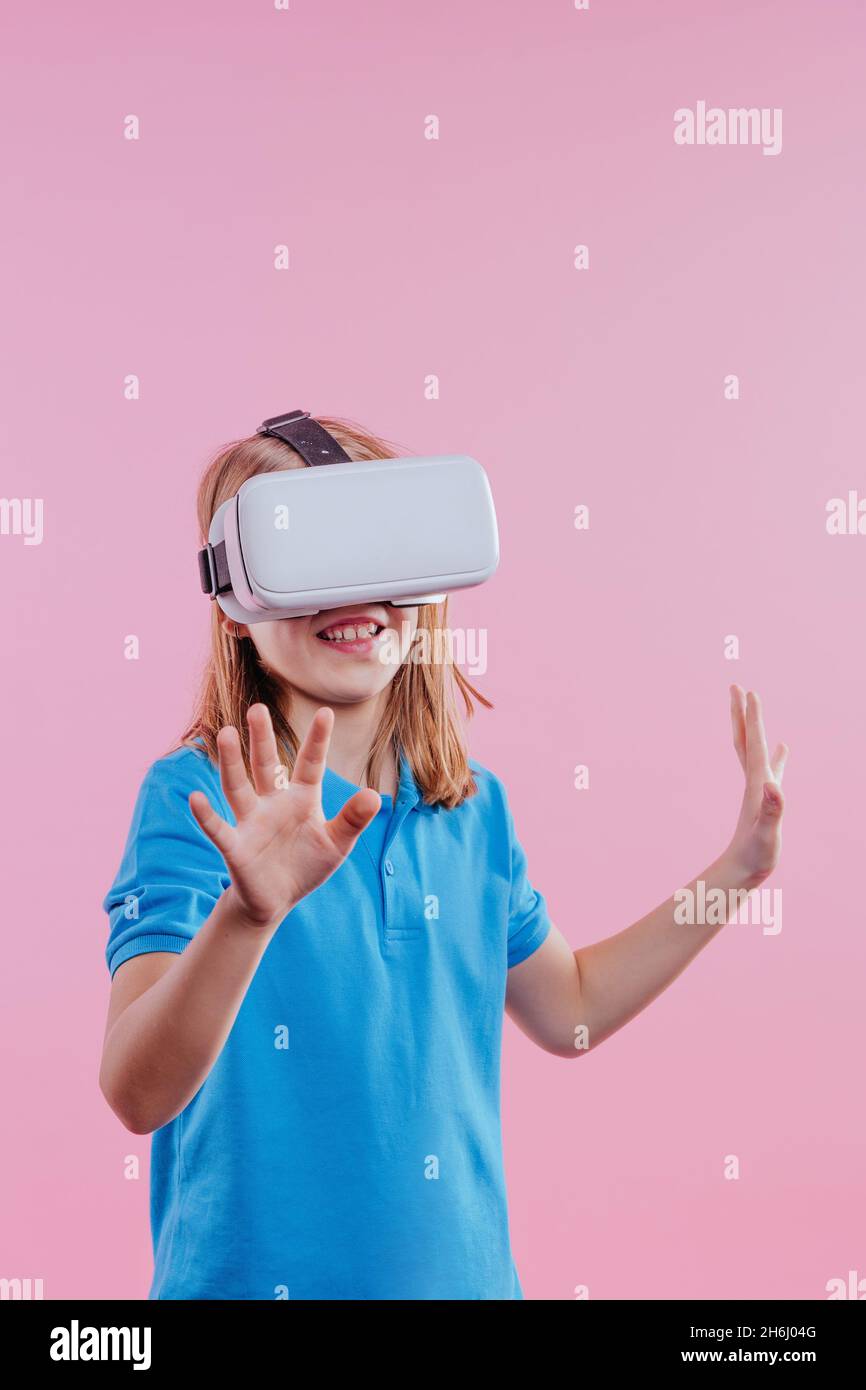 Teenager girl wearing virtual reality device. Studio portrait on pink ...