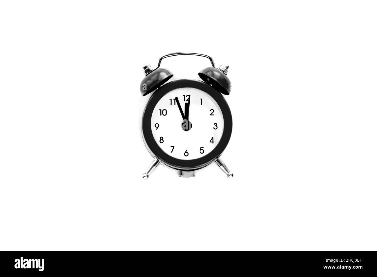 Black vintage alarm clock shows 12 o'clock isolated on white background ...