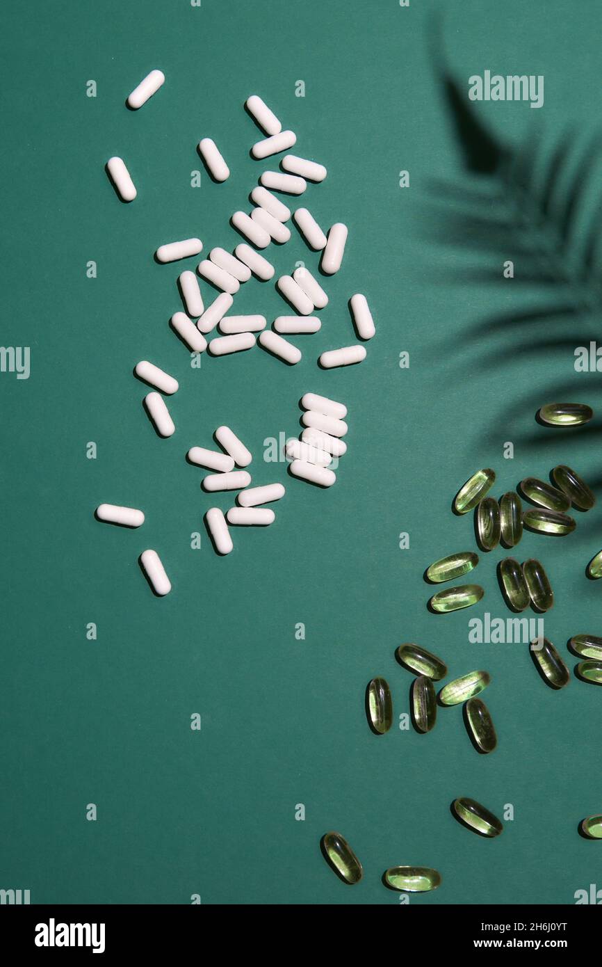 Many white capsule pills on a colorful background. Supplements and ...
