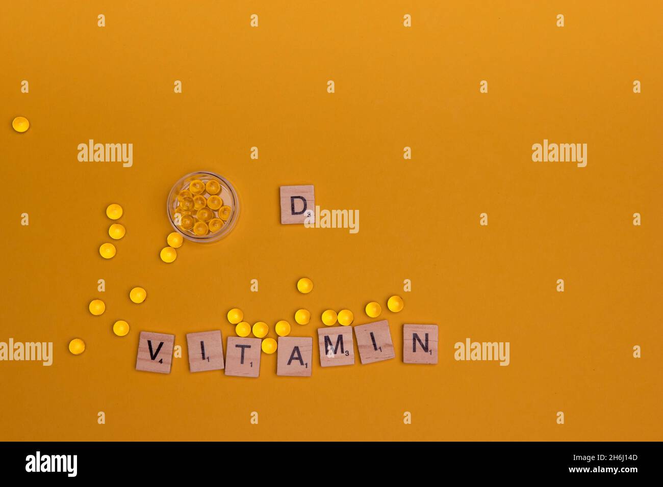 Many transparent pills sun vitamin D3 on a colorful yellow background ...