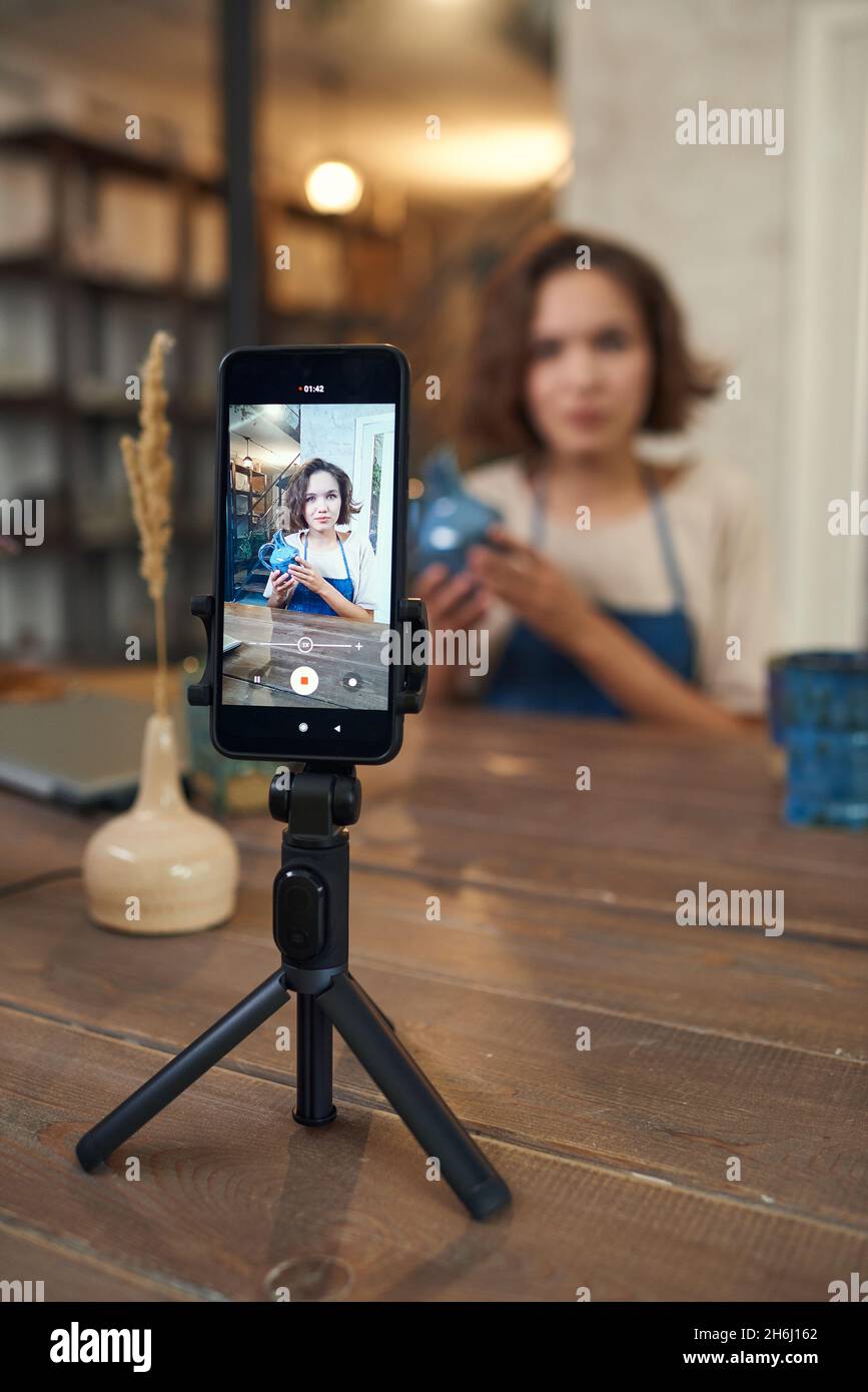 Smartphone with young craftswoman on screen giving masterclass for ...