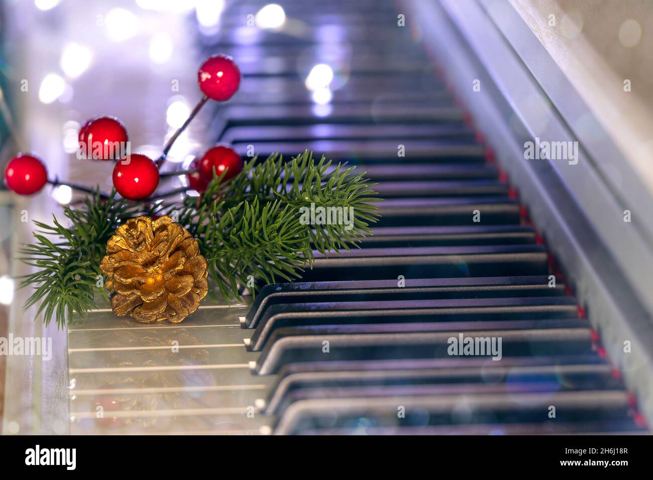 piano keys with golden pine cone, christmas tree branch and red berries ...