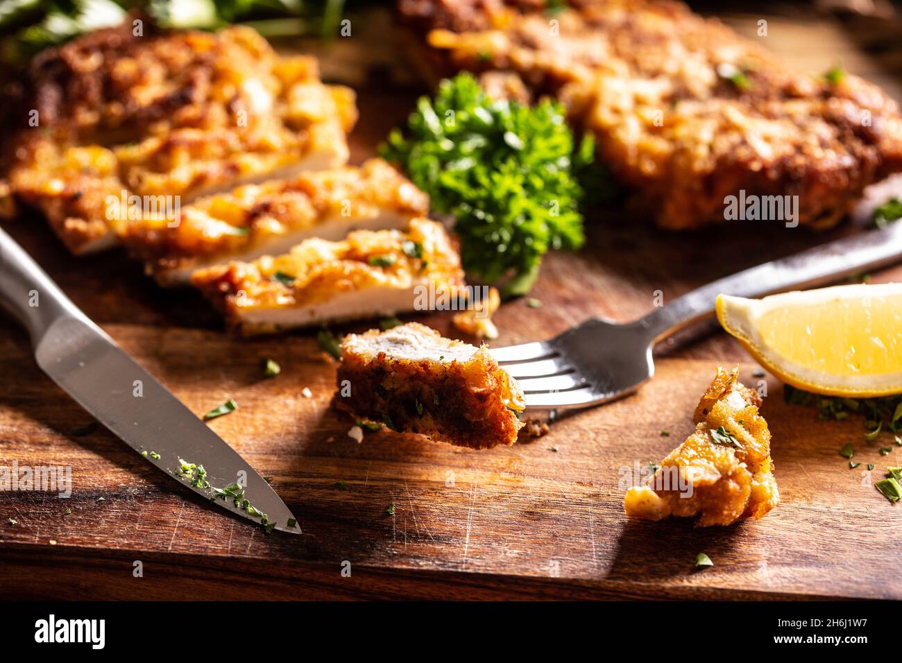 Viennese chicken steak on a fork. Traditional Austrian and German dish ...