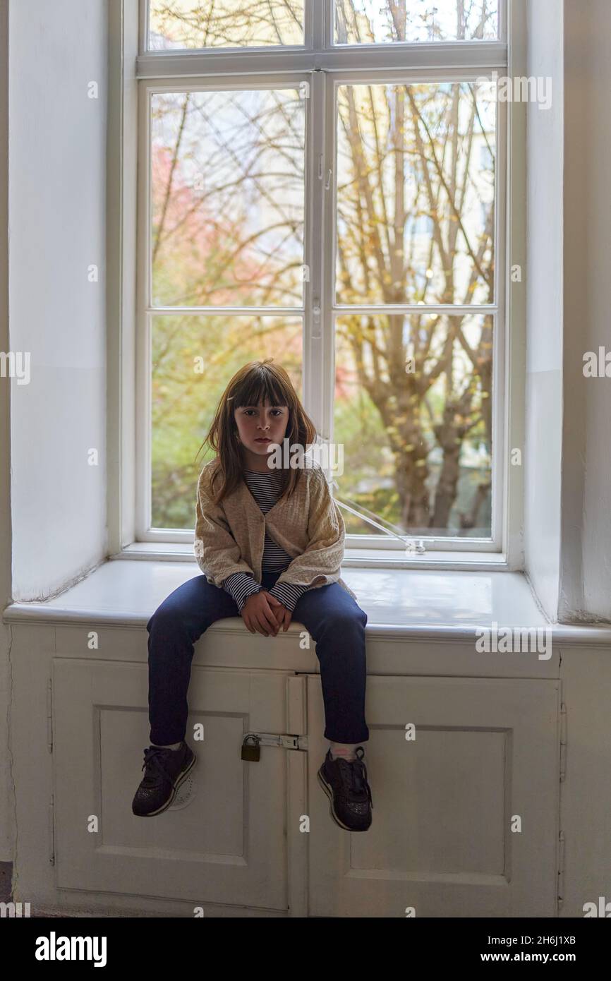 Girl sitting on a windowsill, on the window Stock Photo - Alamy