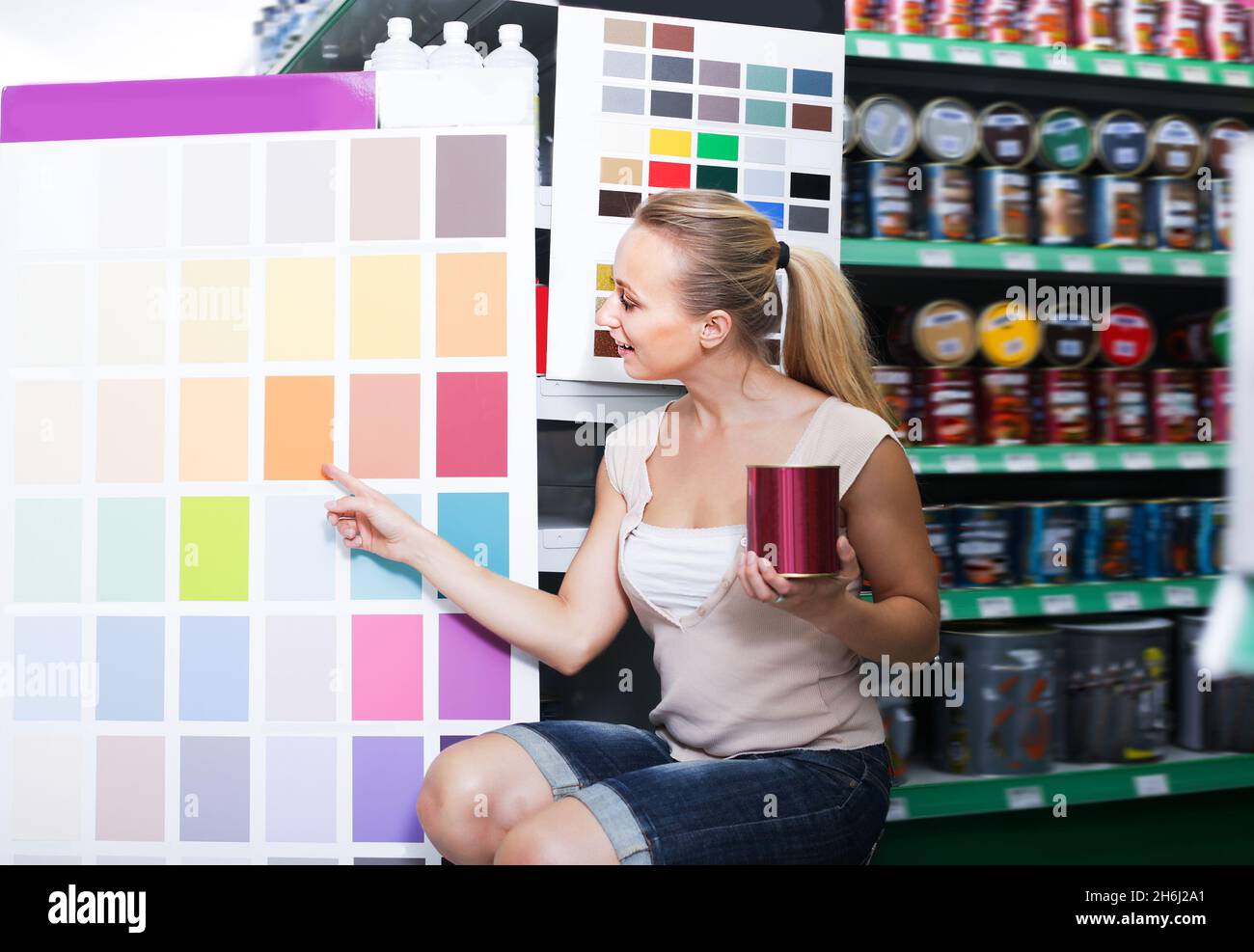 Positive young woman picking color for paint Stock Photo - Alamy