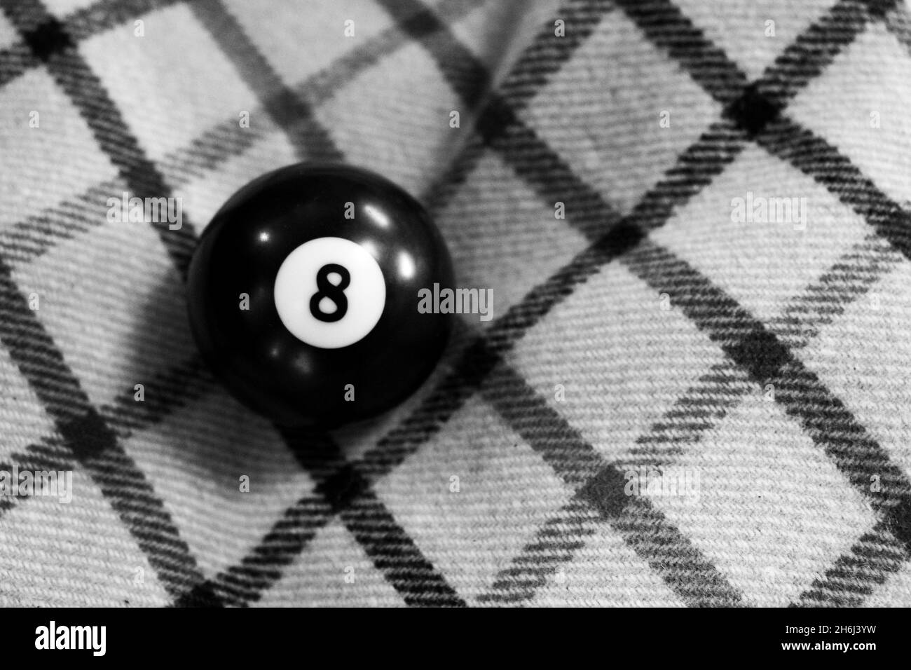Grayscale shot of a billiard ball number 8 on a checkered fabric Stock ...