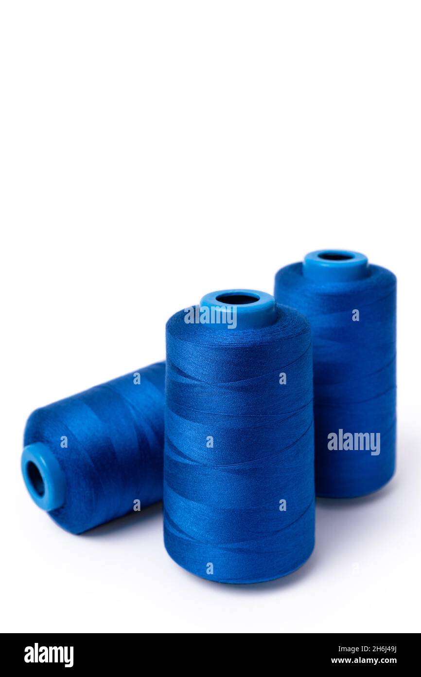 Threads of trendy electric blue on a white background. Side view of a ...