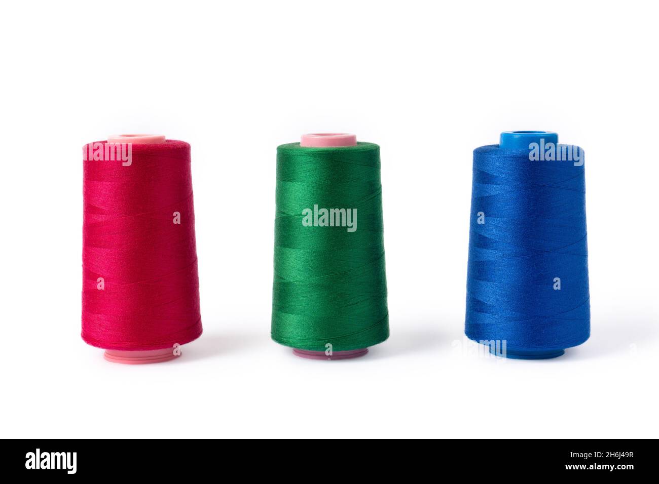 Pink, blue and green threads on a white background. Side view of ...