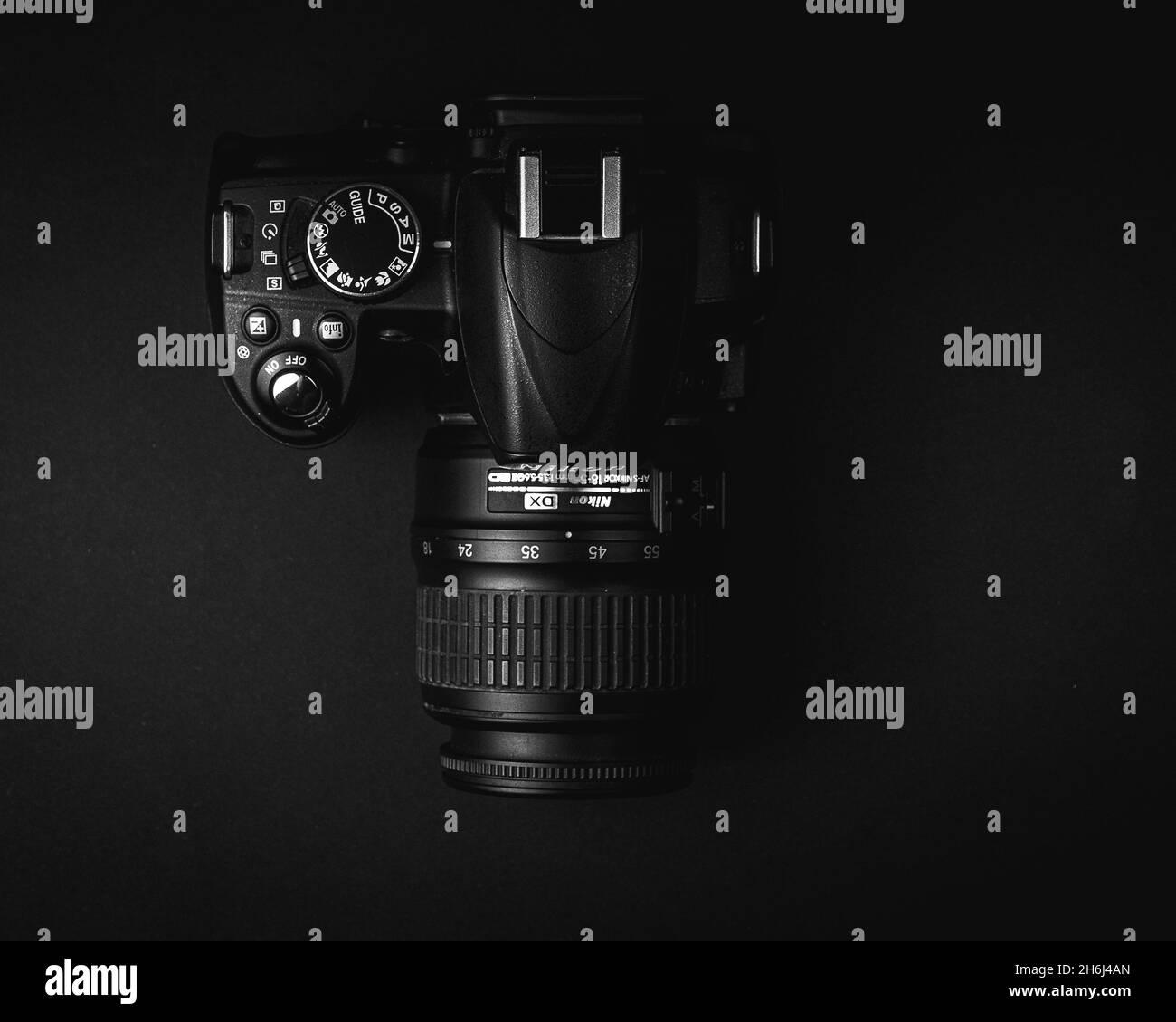 Top view of black and white DSLR camera on a black backdrop, flat lay ...