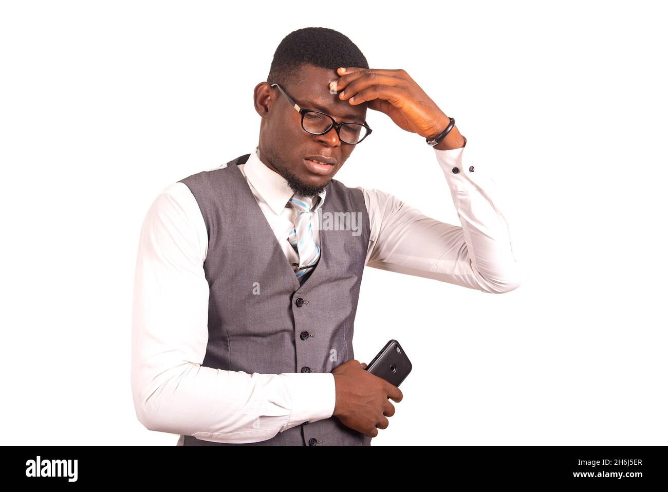 young businessman holding a mobile phone and suffering from a headache ...