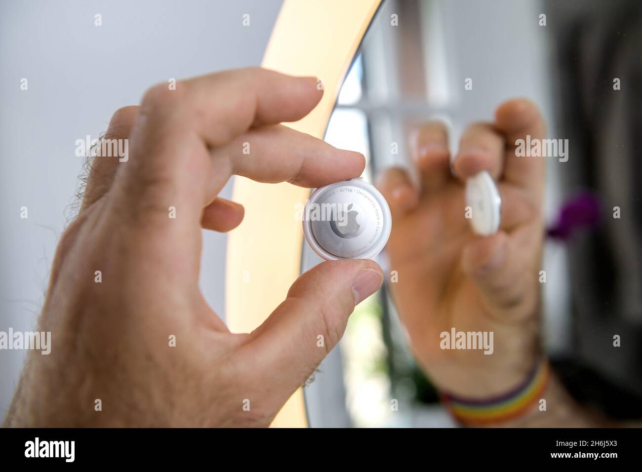 Man hand hoding new Apple Computers AirTag tracker device reflected in ...