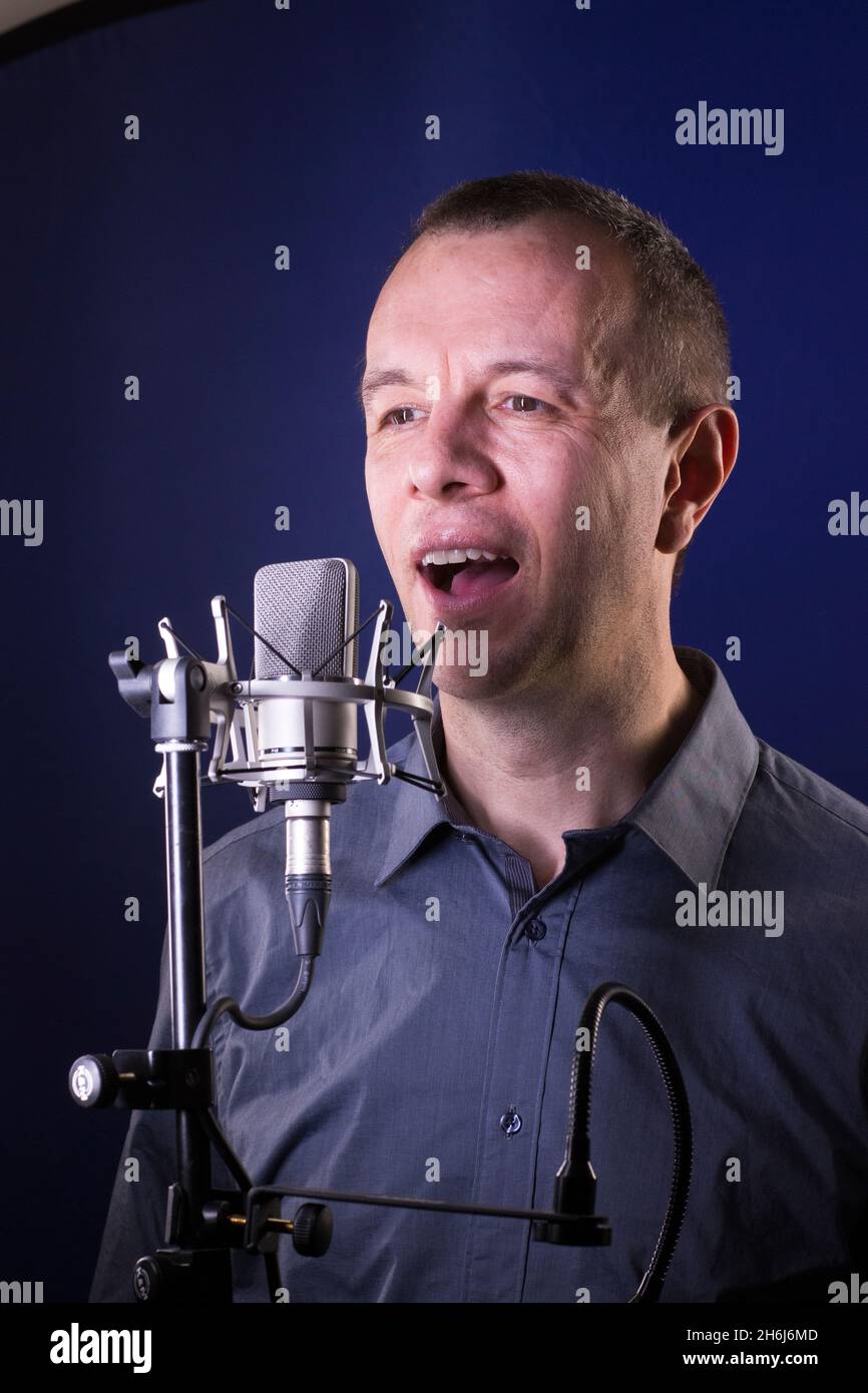 Voiceover artist voice actor in vocal recording studio with larg ...