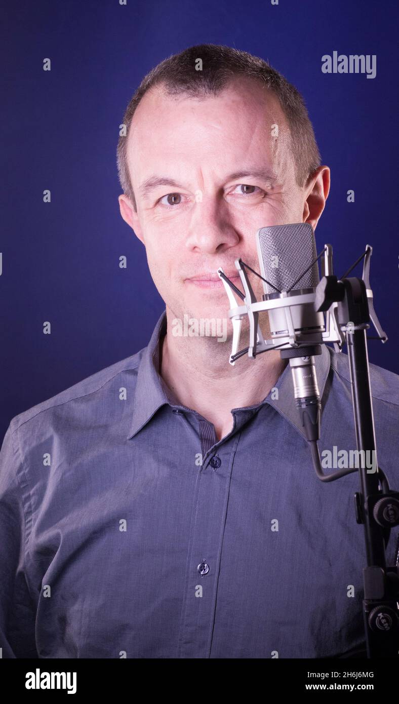 Voiceover artist voice actor in vocal recording studio with larg ...