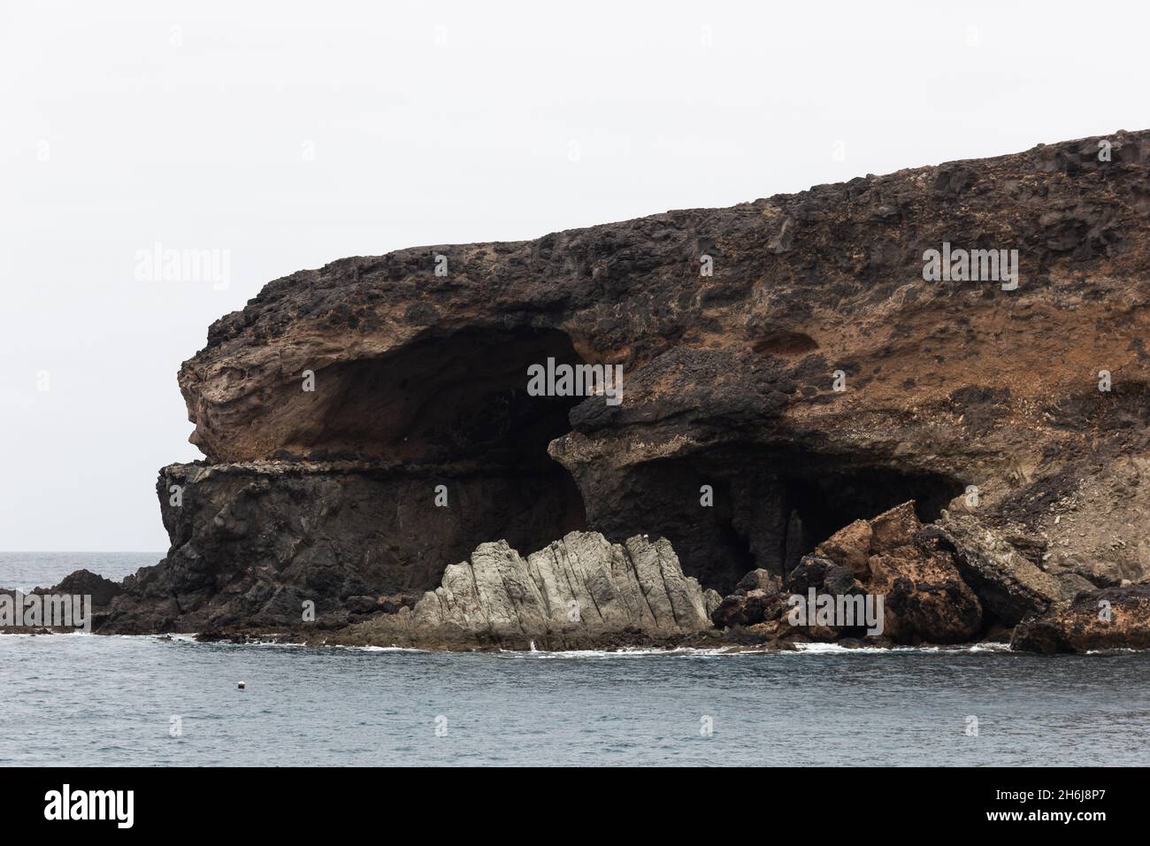Ajuy black cave on cliff edge with sharp rock formation by the sea in ...