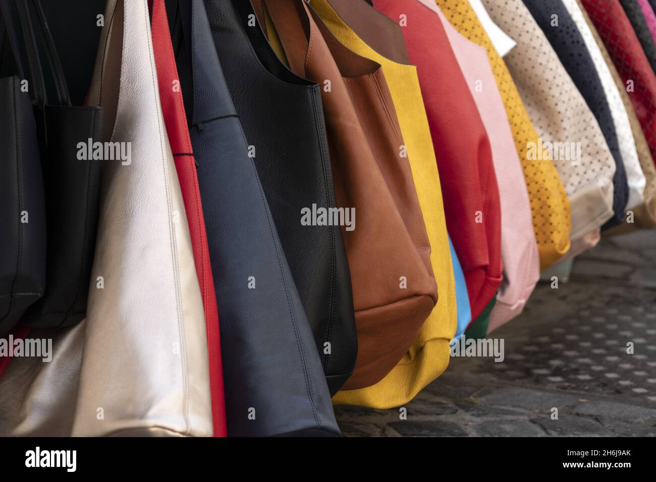 different colors leather woman bags on display at the market Stock ...