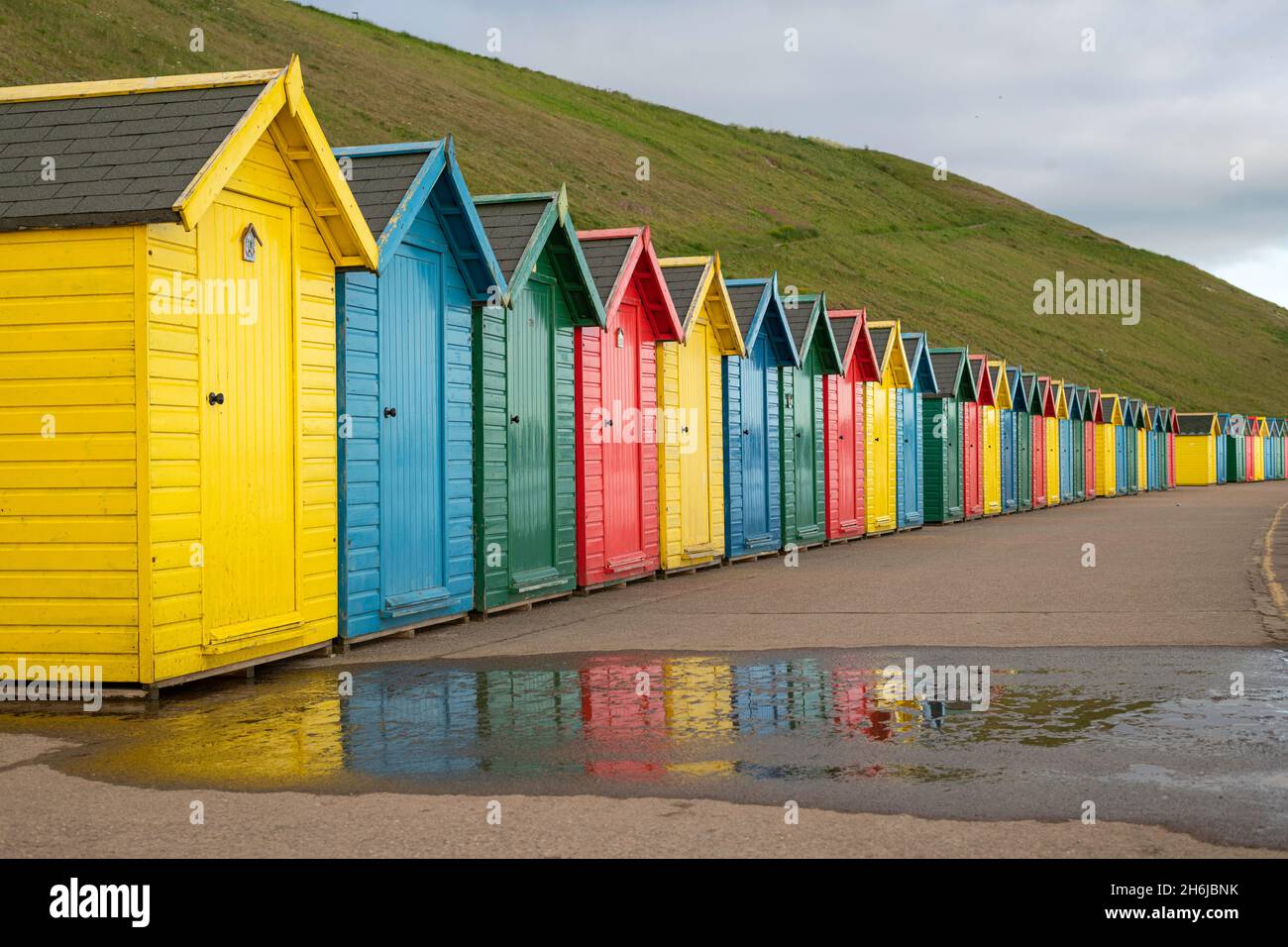 Row of colourful wooden beach huts along the promenade at Whitby Stock ...