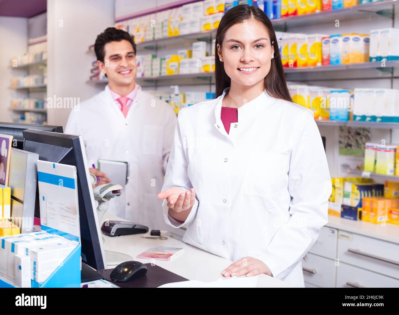 Pharmacist standing at pay desk Stock Photo - Alamy
