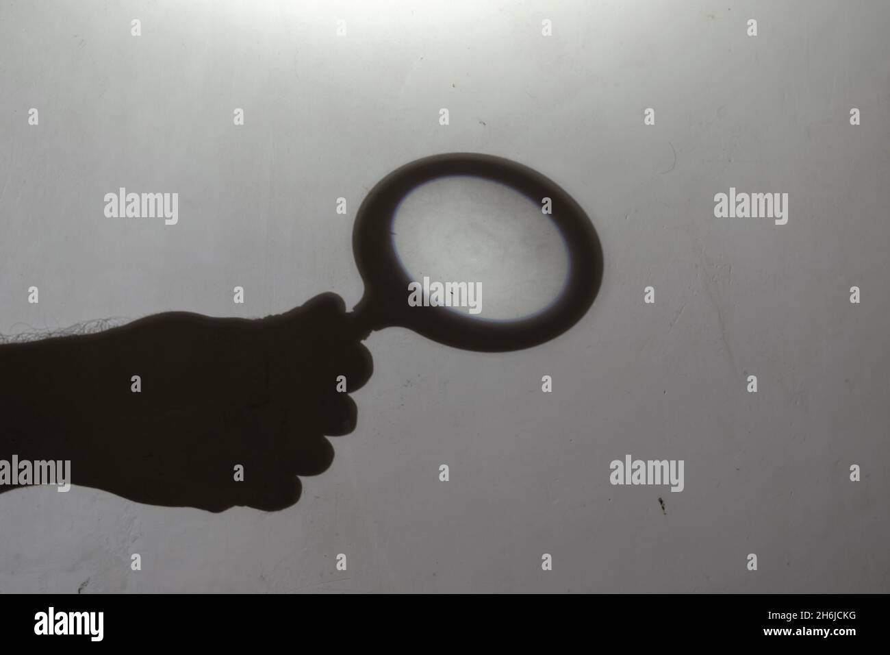 Blur, defocus, noise, grain effect. Dark silhouette of a hand holding a ...